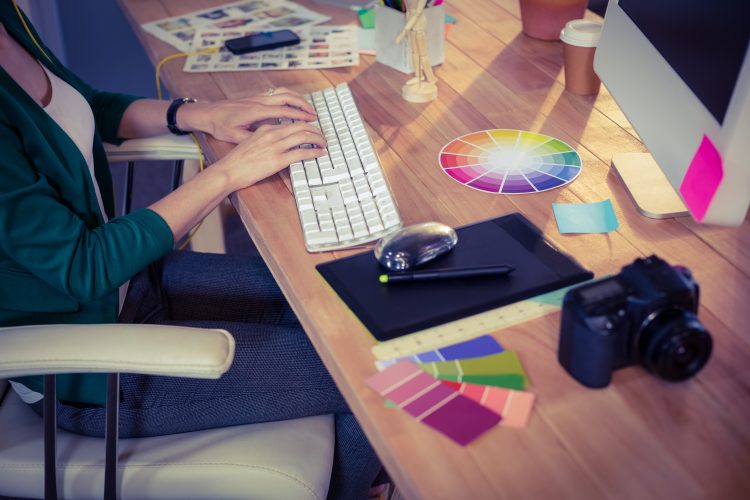 Designer working at her desk in creative office - MakeWebEasy Blog